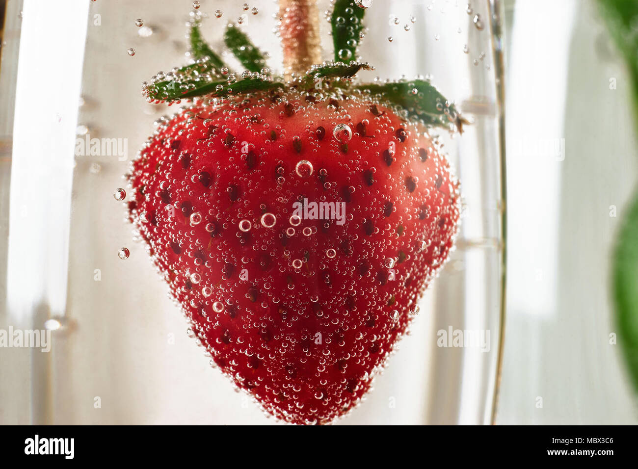Strawberry inside a glass with champagne Stock Photo - Alamy