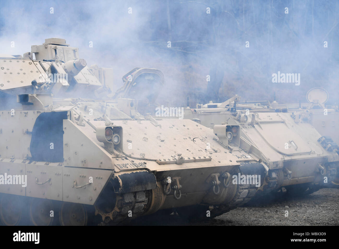 A Bradley Fighting Vehicle and M121 120 mm mortar system sit next to ...