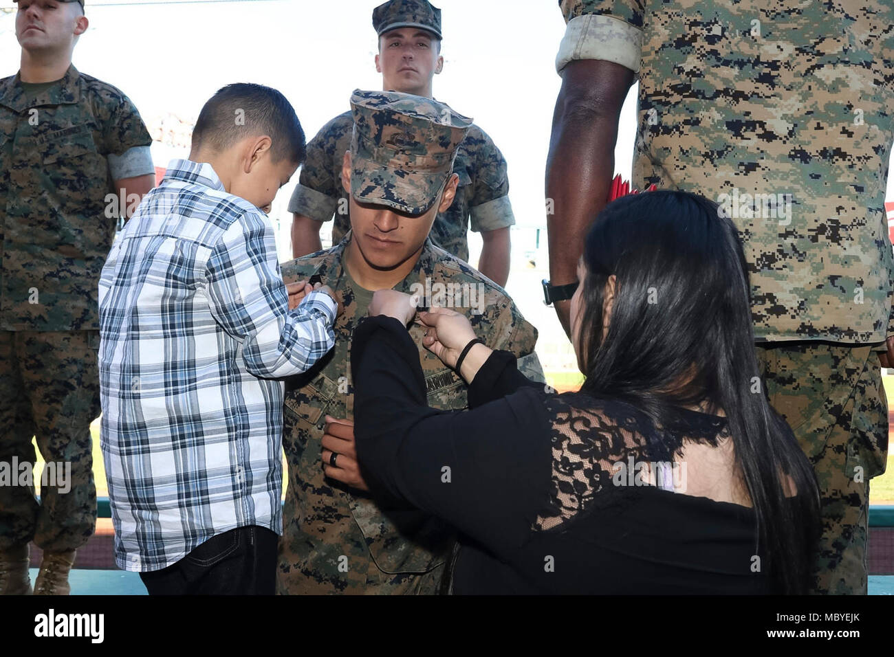 The Mendoza family pins U.S. Marine Corps Staff Sgt. Antonio Mendoza ...