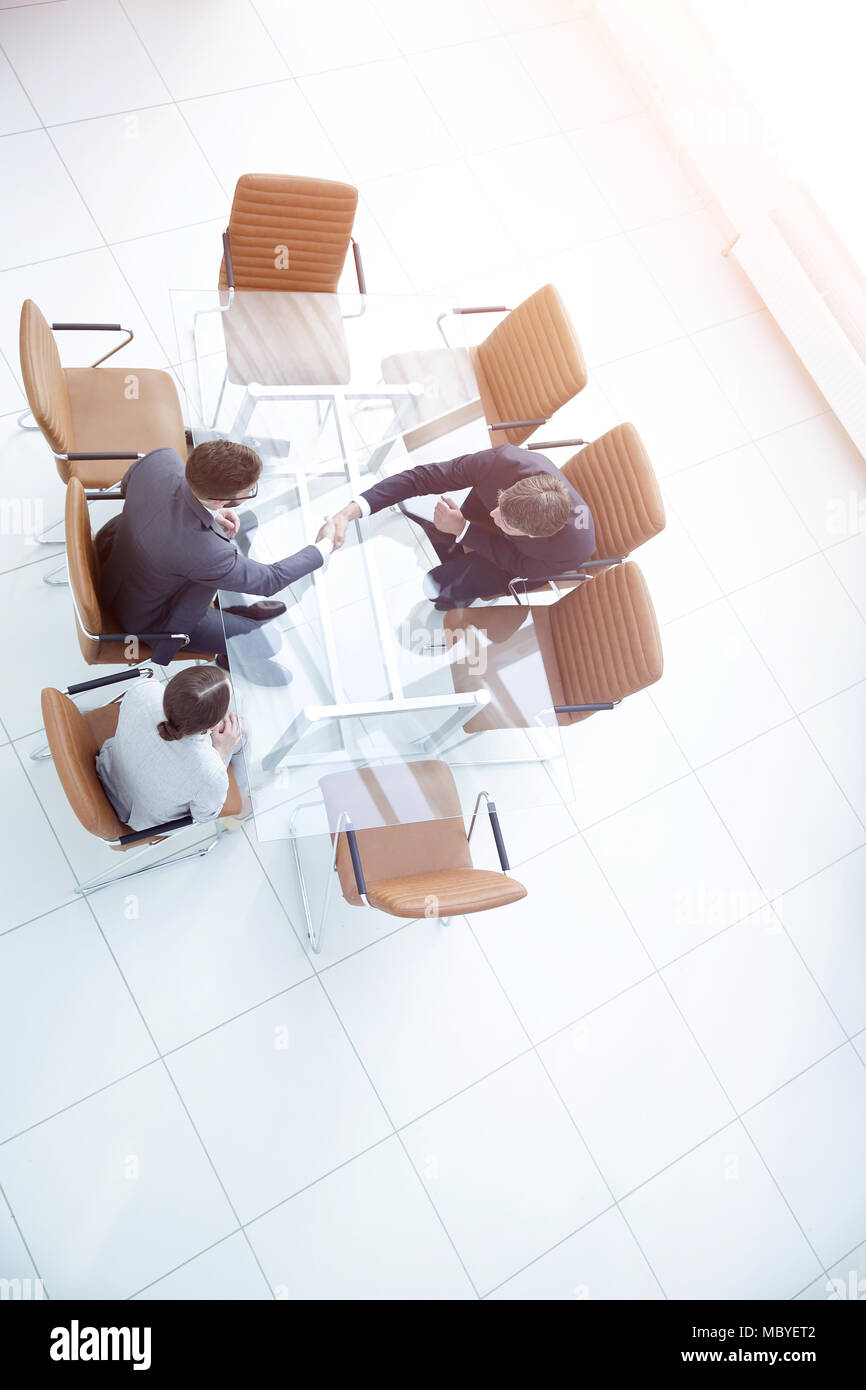 Handshake across table hi-res stock photography and images - Alamy