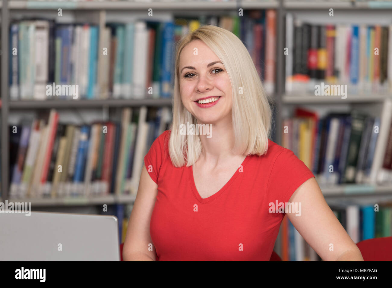 Pretty Female Student With Books Working in a High School Library Stock ...