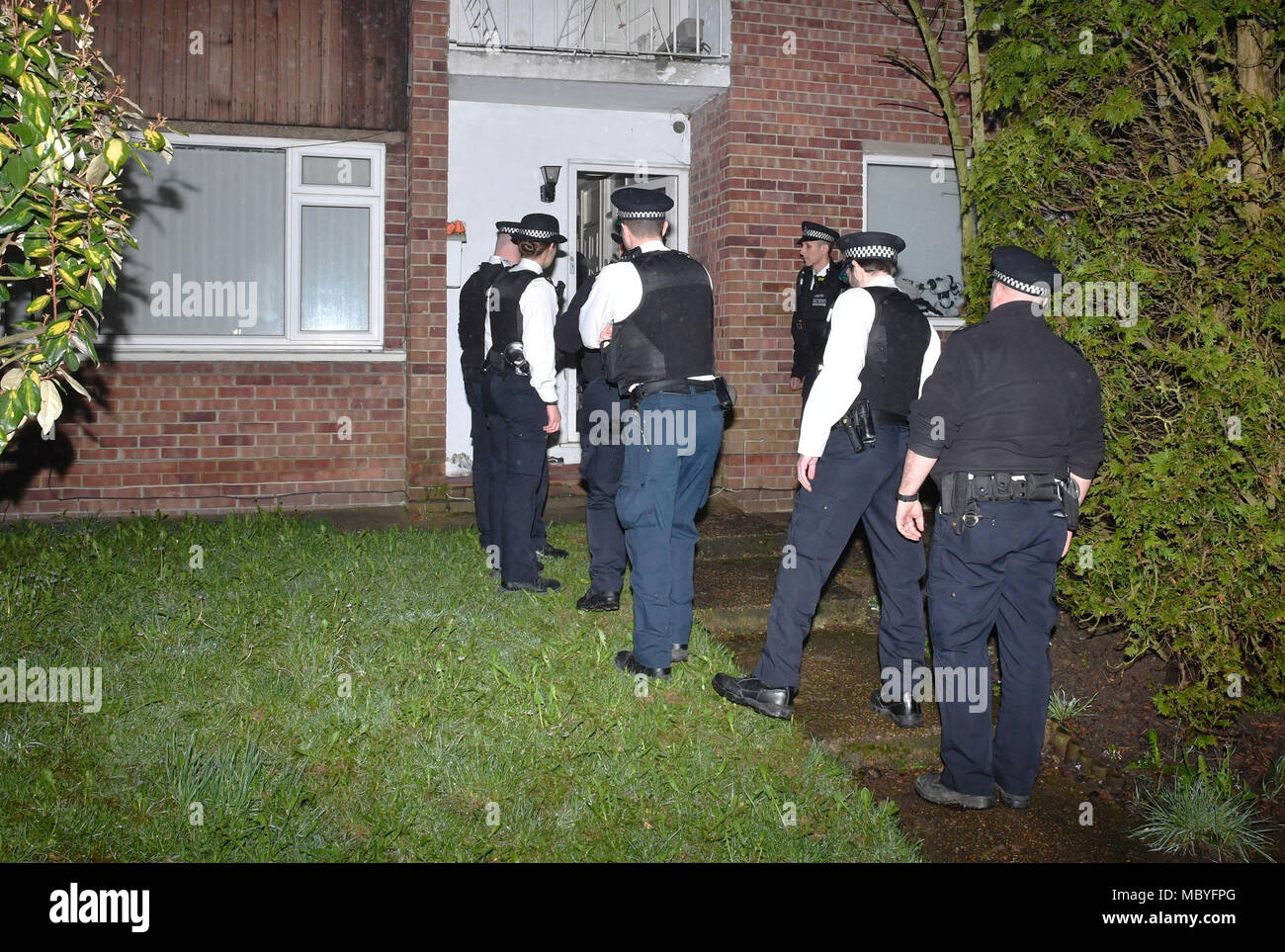 A group of Metropolitan Police officers enter a ground floor flat where ...
