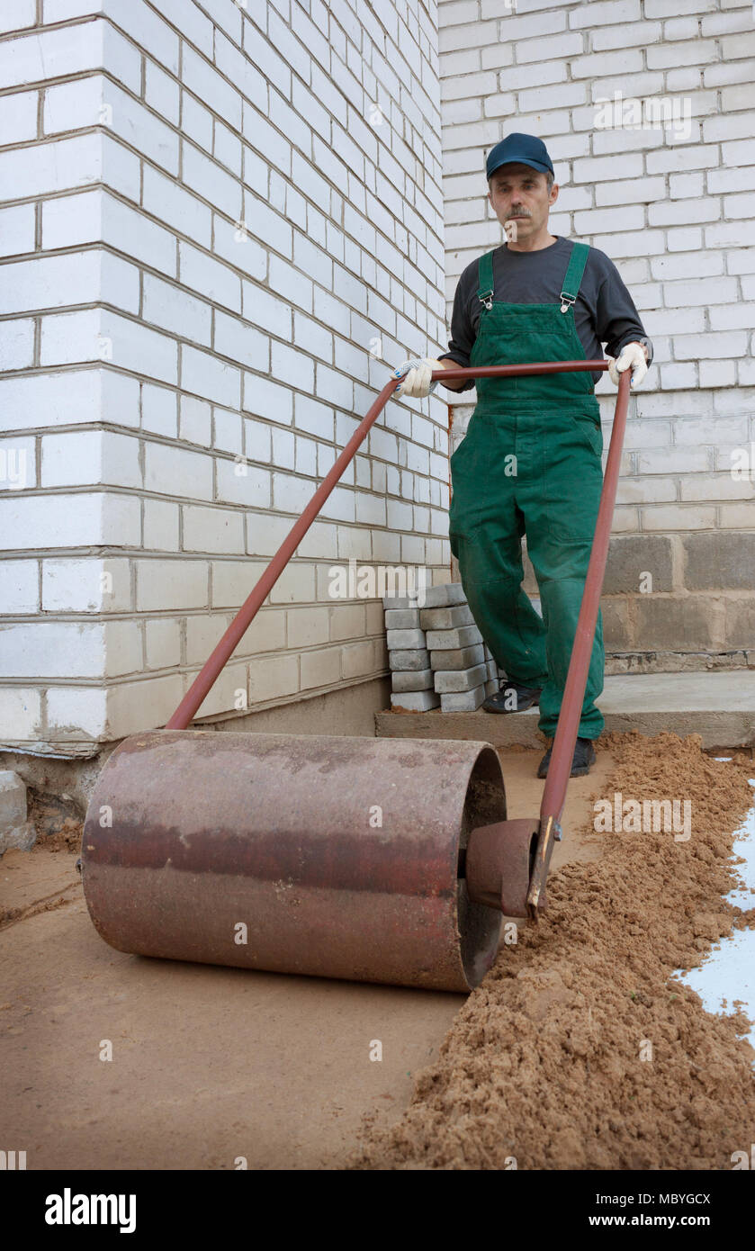Soil compaction roller manually before creating sidewalk Stock Photo ...