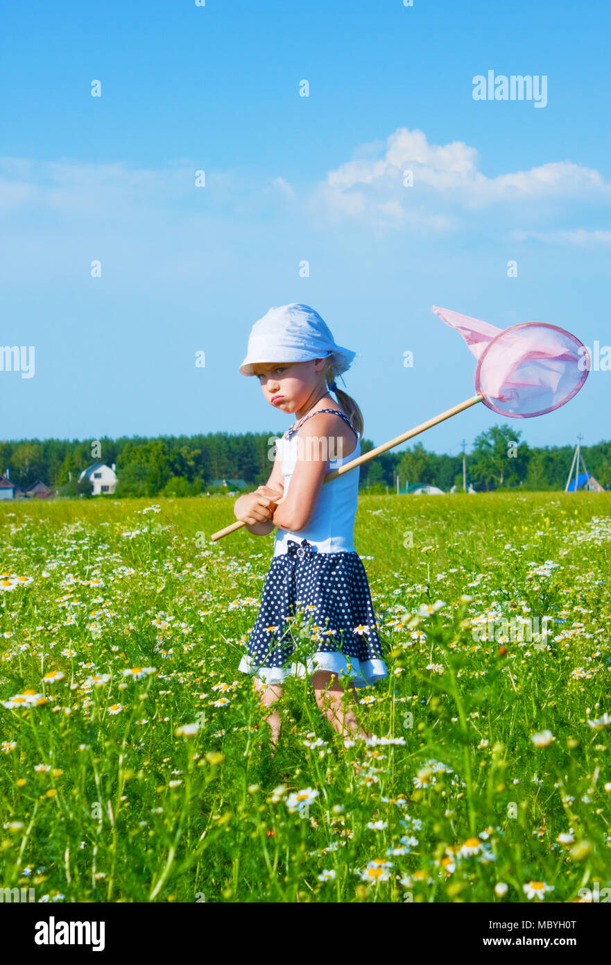 The small angry girl on a meadow with a net Stock Photo - Alamy