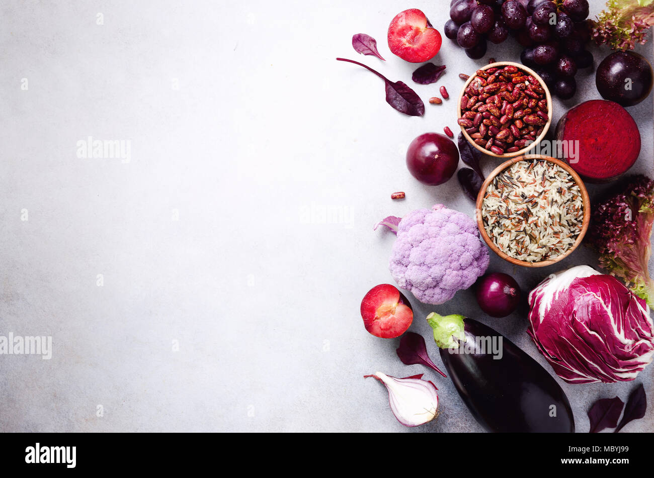 Purple vegetables, fruits on grey background. Violet eggplant, beets ...
