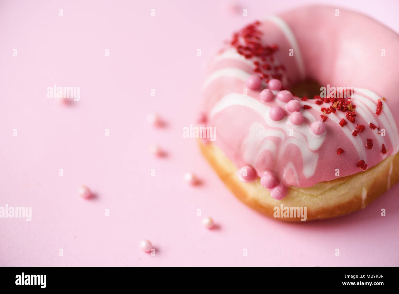 Sweet doughnut with pink icing on pastel background. Tasty donut on ...