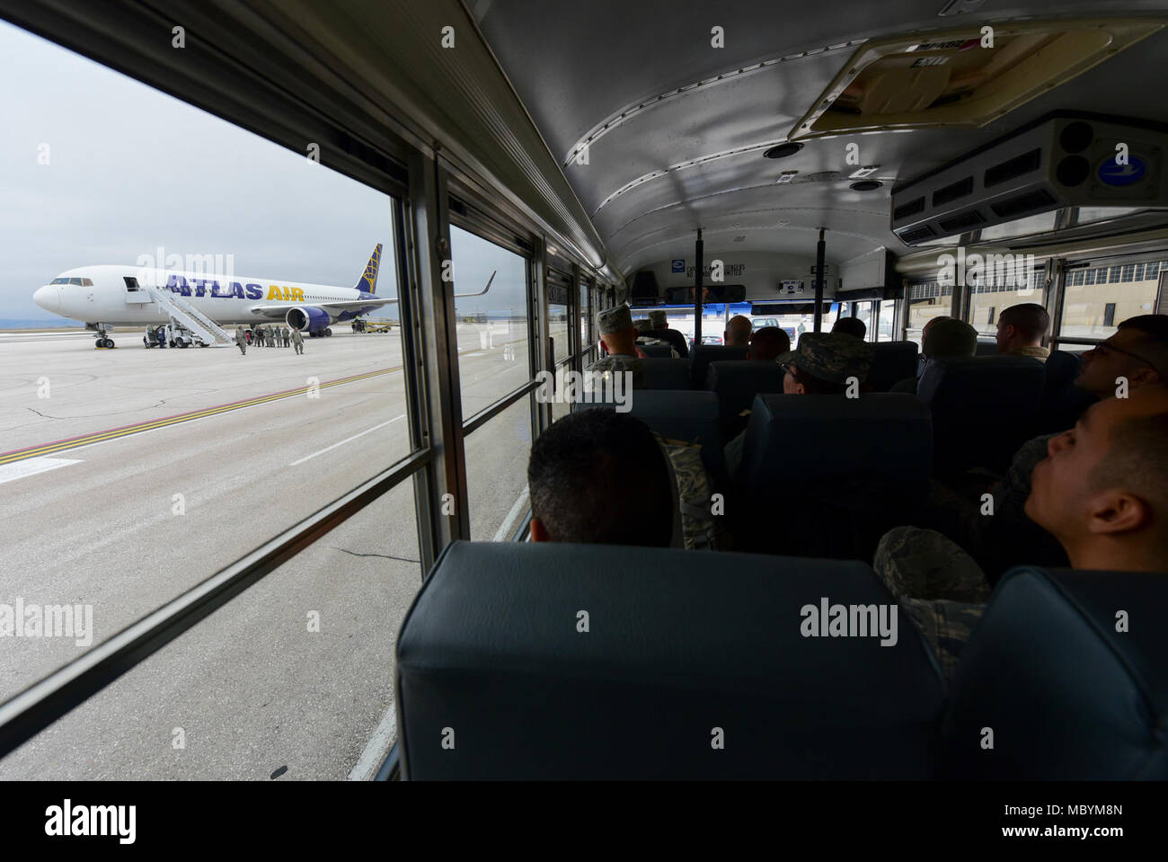 A bus carrying Airmen transports to an aircraft on the flightline at ...