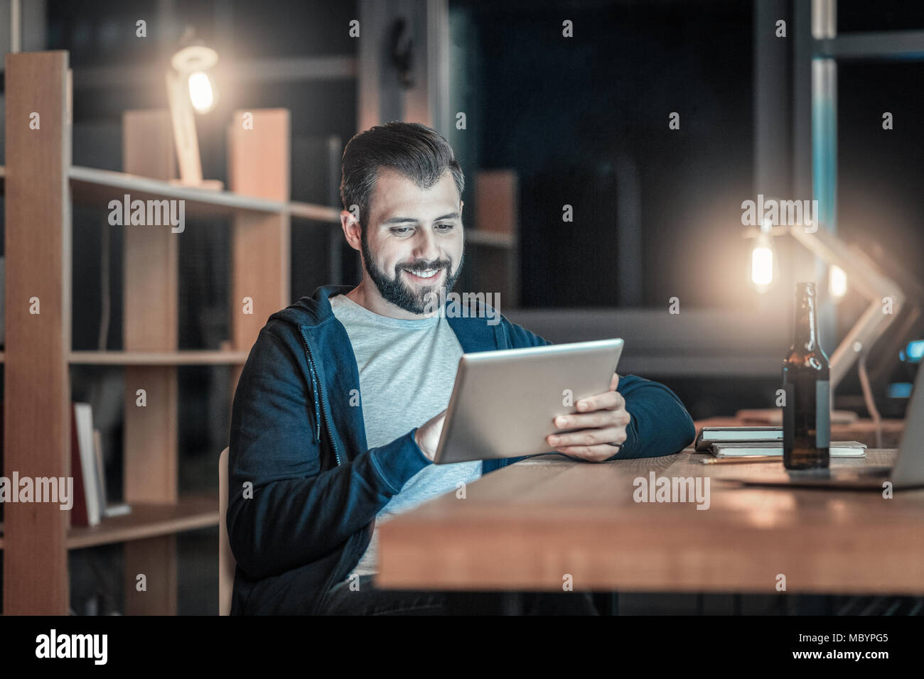 Joyful IT guy fixing tablet Stock Photo - Alamy
