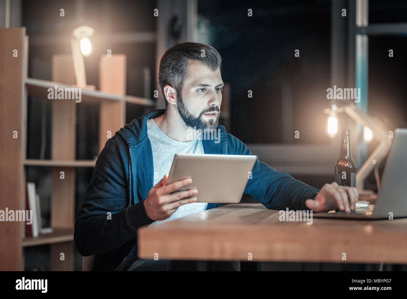 Attractive IT guy checking tablet work Stock Photo - Alamy