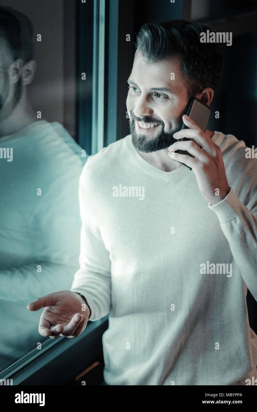 Energetic satisfied man having phone conversation Stock Photo - Alamy