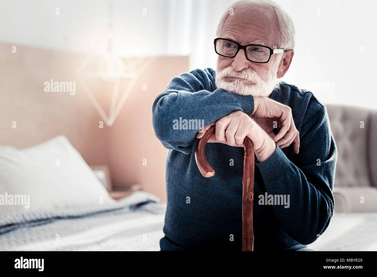 Serious thoughtful man leaning on the walking stick Stock Photo - Alamy