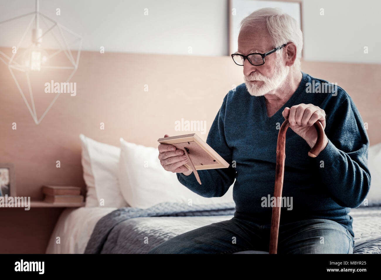 Sad nostalgic man looking at the photo Stock Photo - Alamy