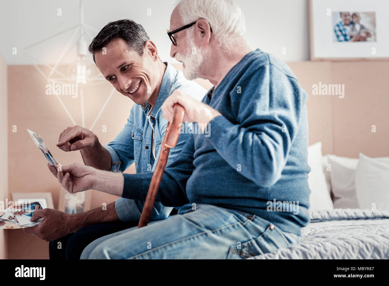 Happy young man looking at the photograph Stock Photo - Alamy