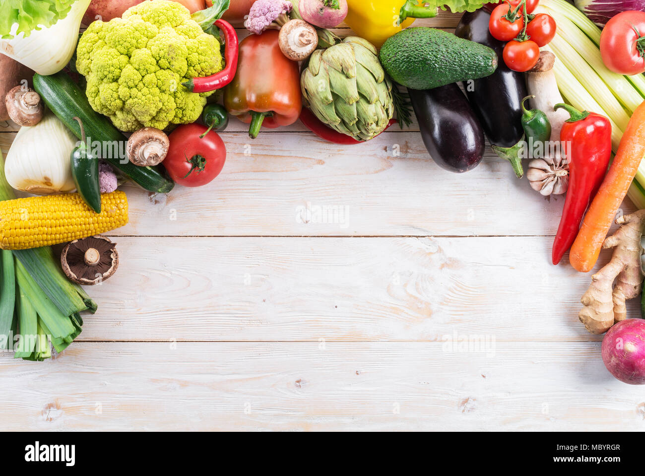 Different colorful vegetables arranged as a frame. Wooden background ...