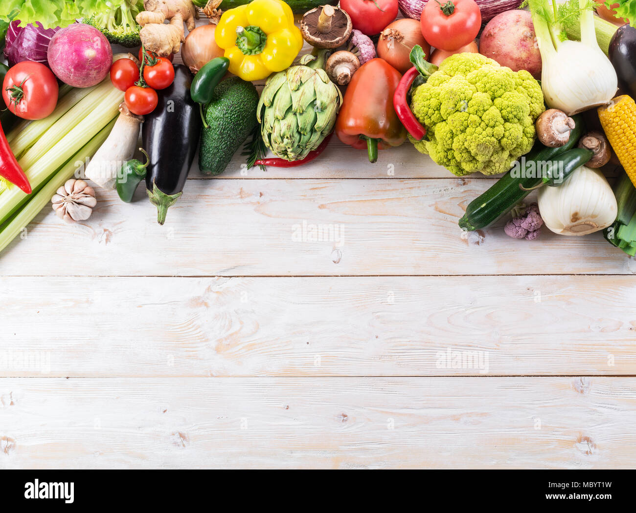 Different colorful vegetables arranged as a frame. Wooden background ...