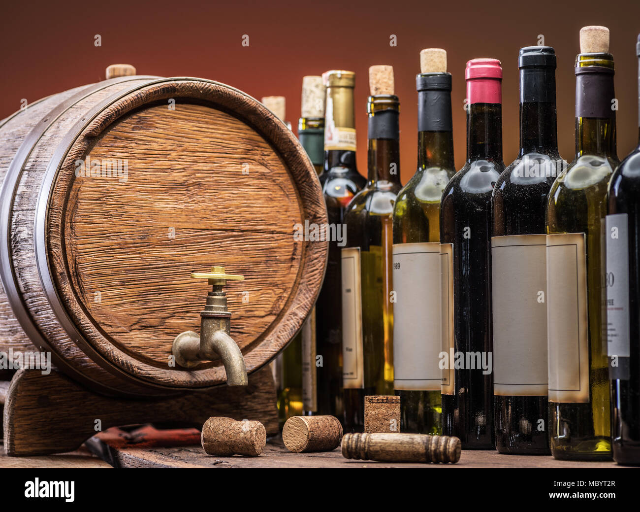 Wine bottles in row and oak wine keg Stock Photo - Alamy
