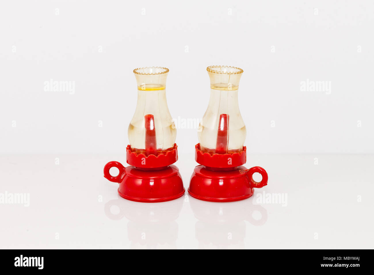 two decorative small red plastic kerosene lamps replica Stock Photo - Alamy