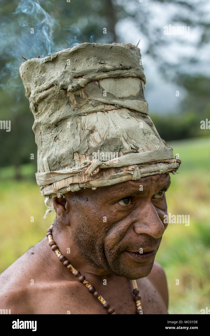 A Simbu fire-maker with traditional smoking headdress, Mount Hagen ...
