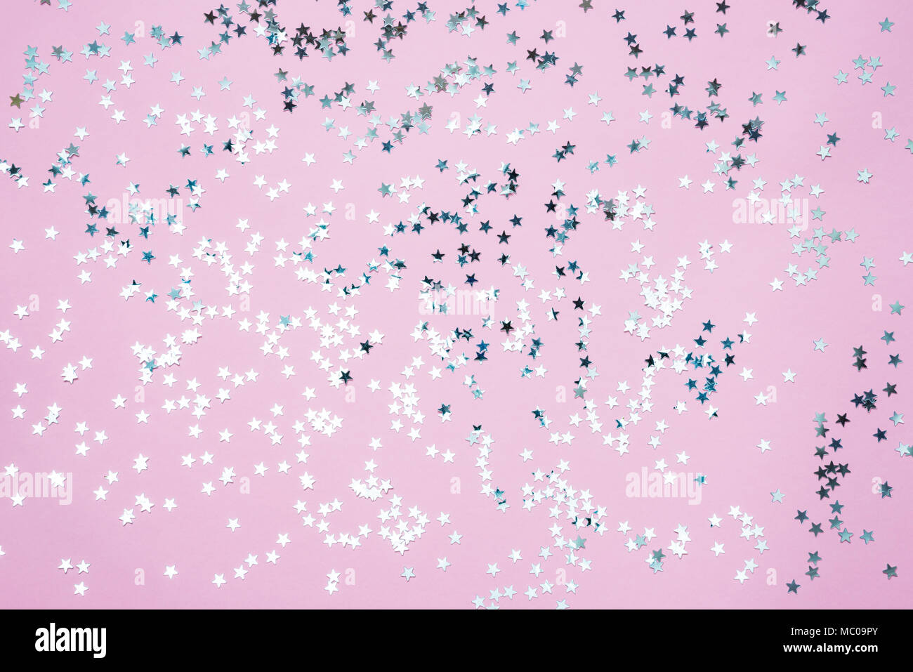 Star shaped silver sequins over pink background Stock Photo - Alamy