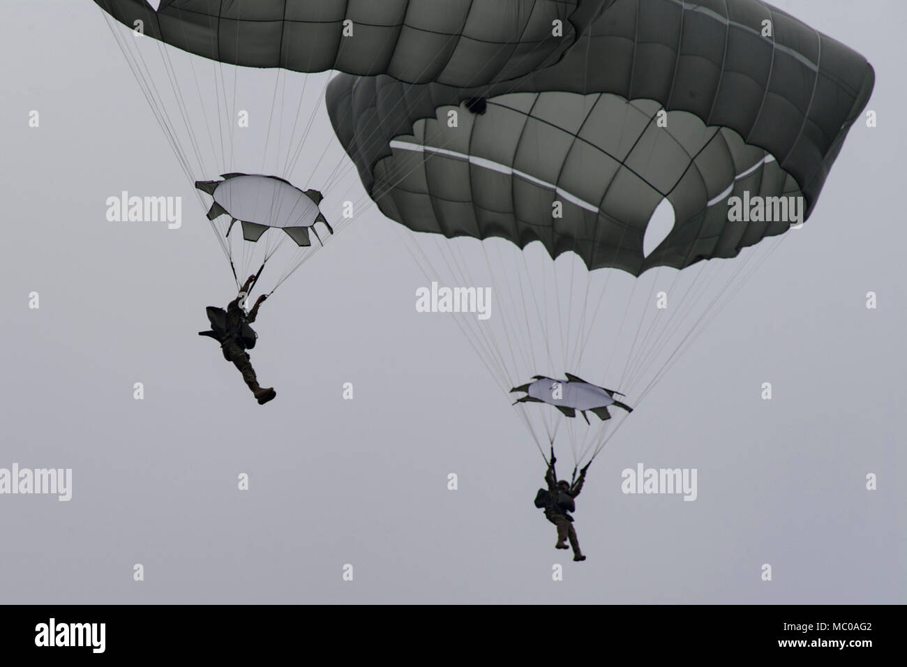 Members of the 820th Base Defense Group drift toward the ground after ...