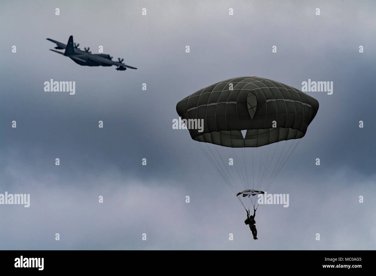 A member of the 820th Base Defense Group drifts toward the ground after ...