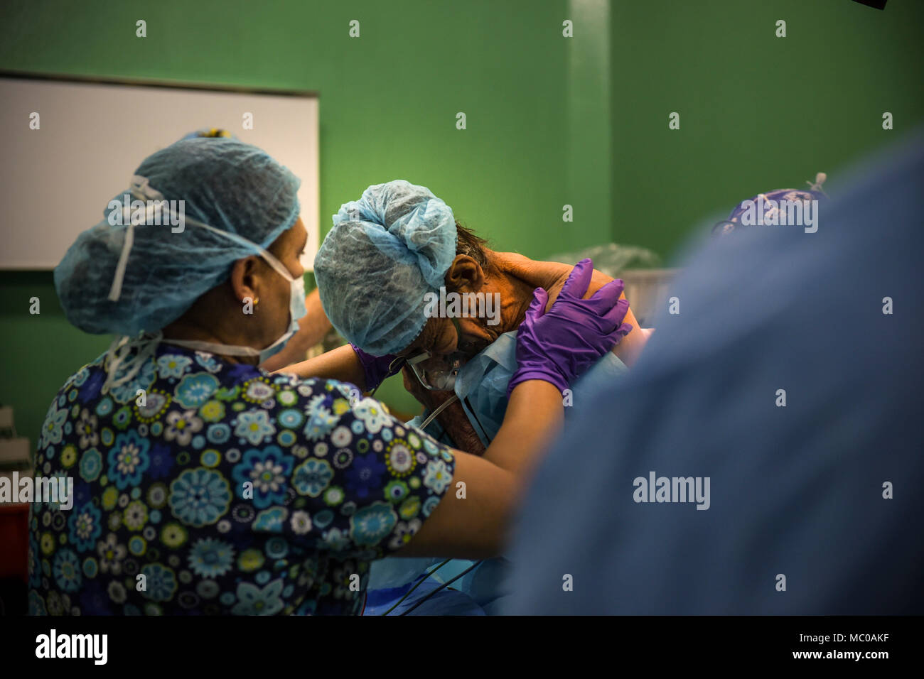 A Honduran nurse holds a patient prior to receiving a lumbar anesthetic ...