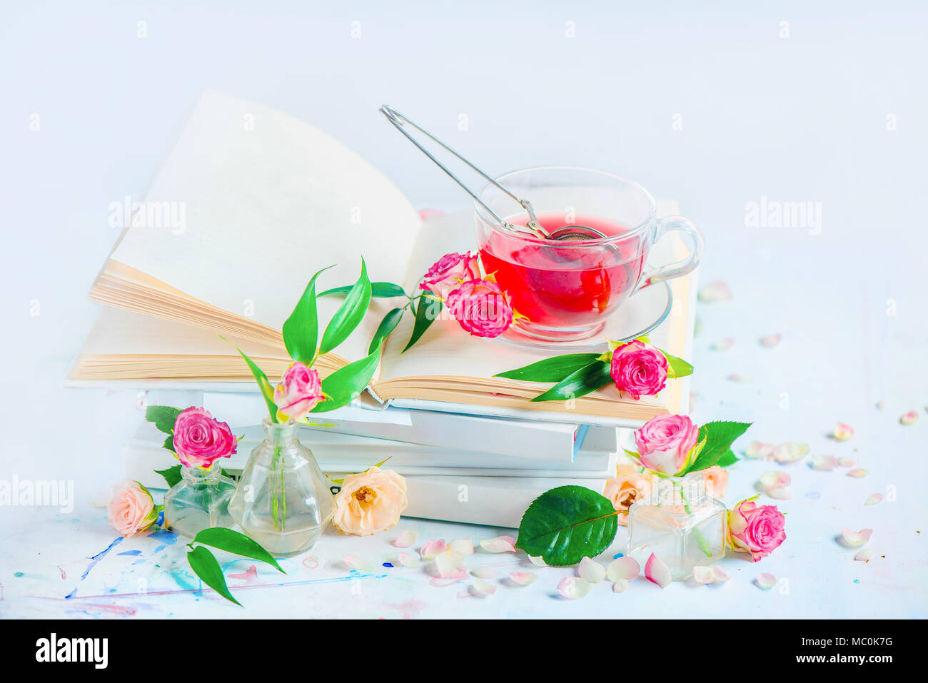Stack of white books with a cup of herbal tea. High key still life with ...