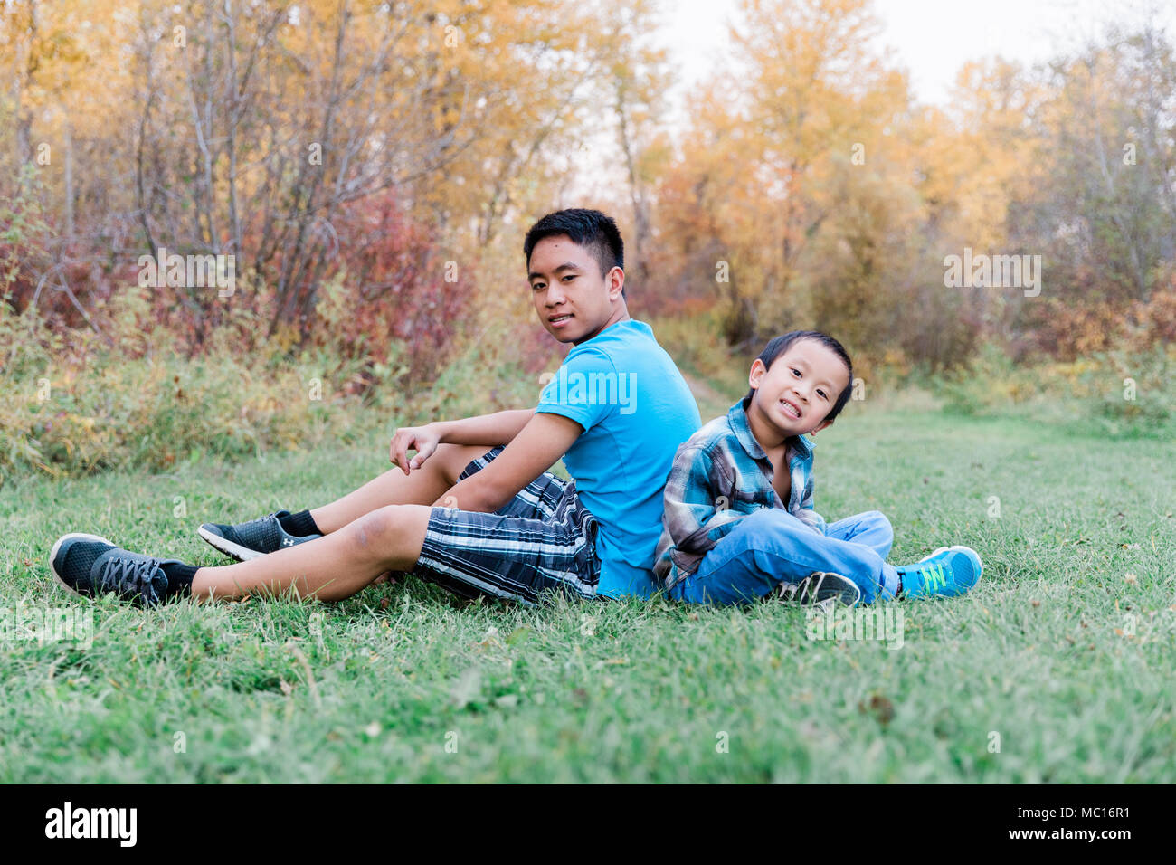 fall colors, sibling seating and posing for pictorial Stock Photo - Alamy