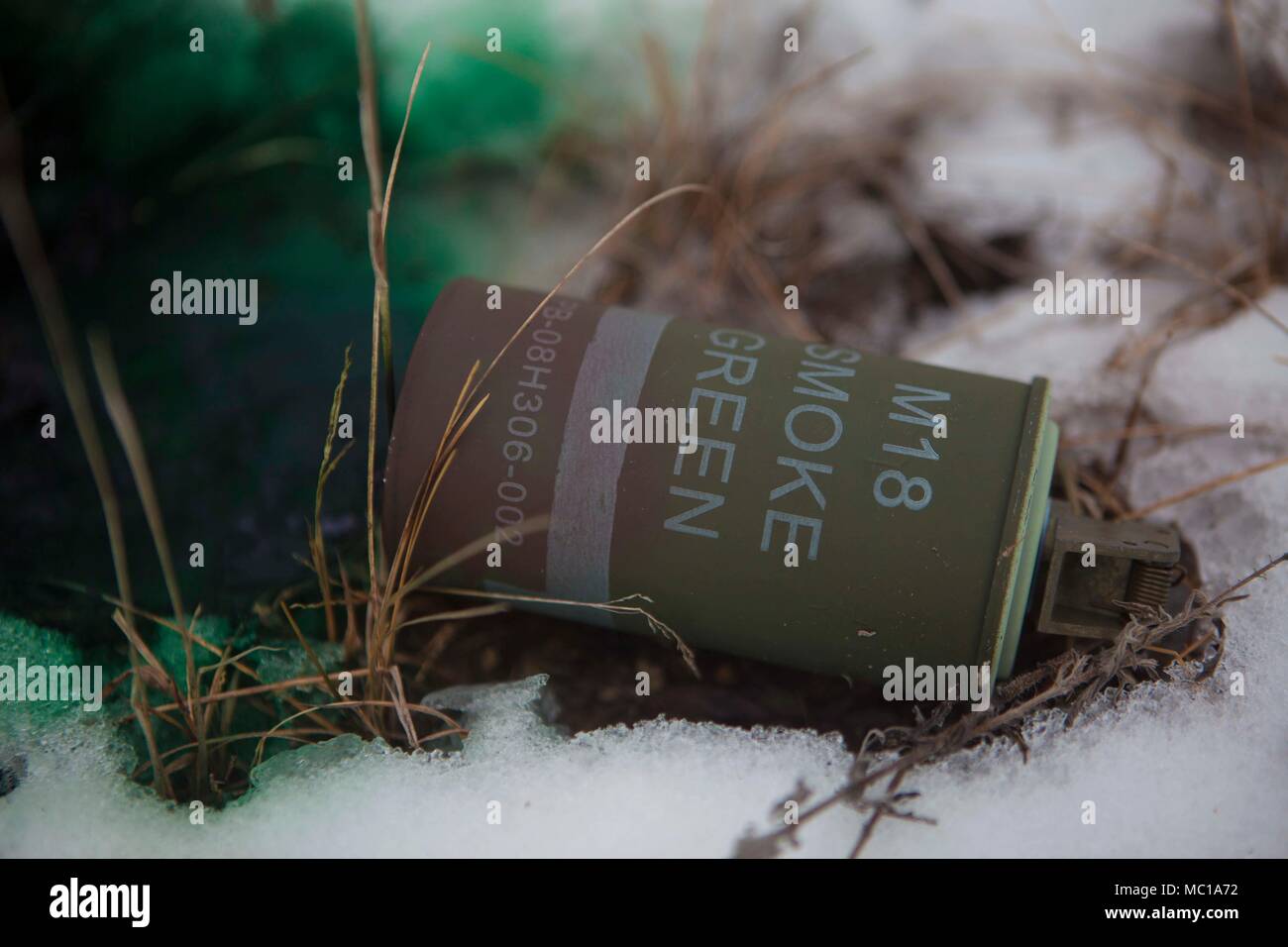 An M18 colored smoke grenade lies in the snow after being used as part ...