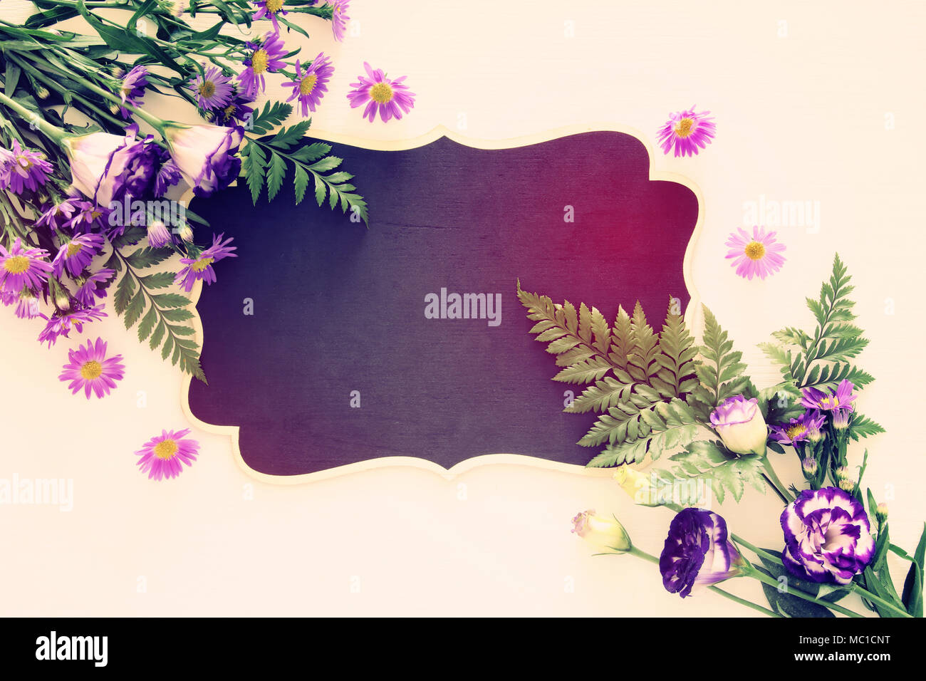 Top view of purple beautiful flowers arrangement and empty blackboard ...