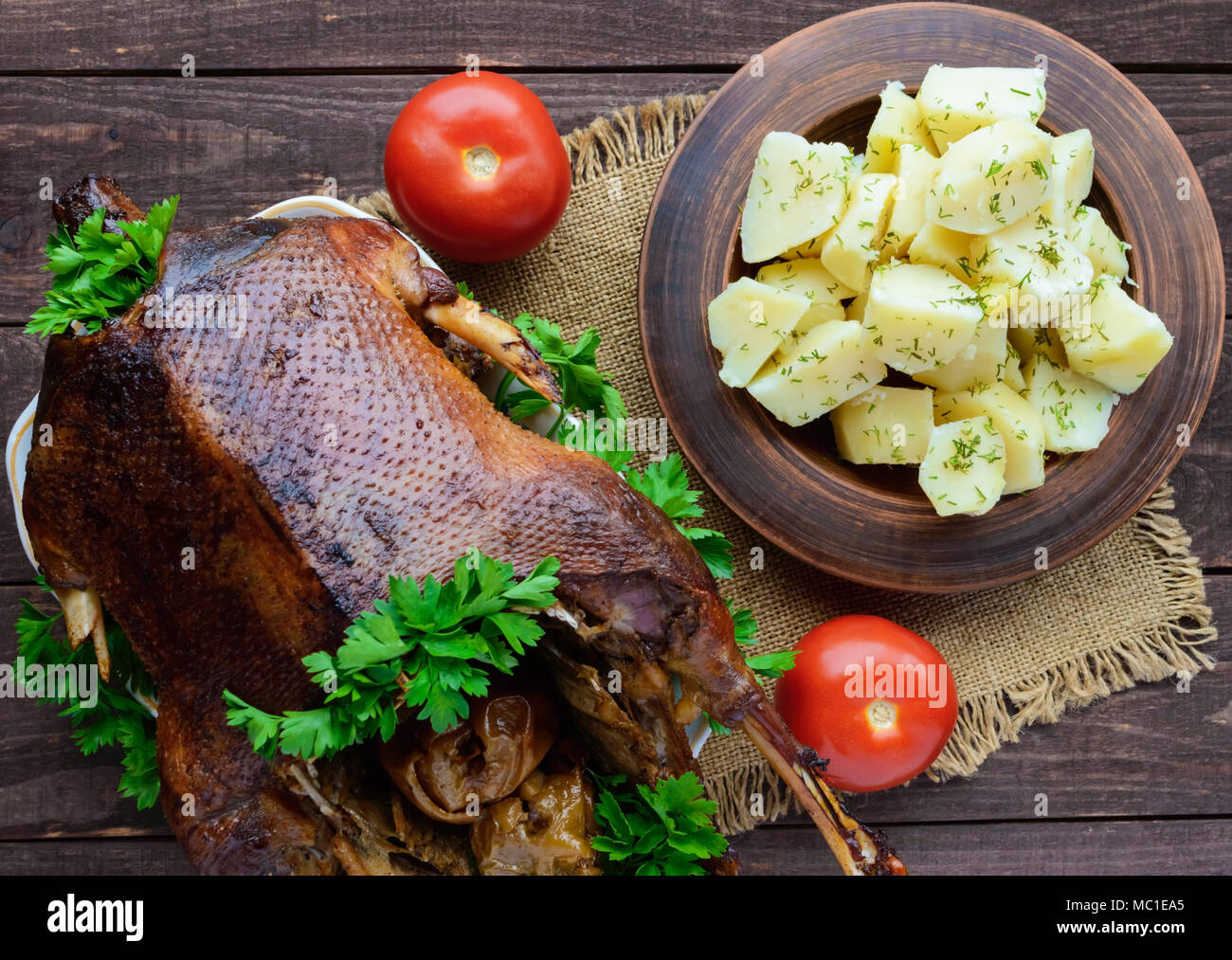 Boiled potatoes in a clay bowl and roasted goose. The top view Stock ...