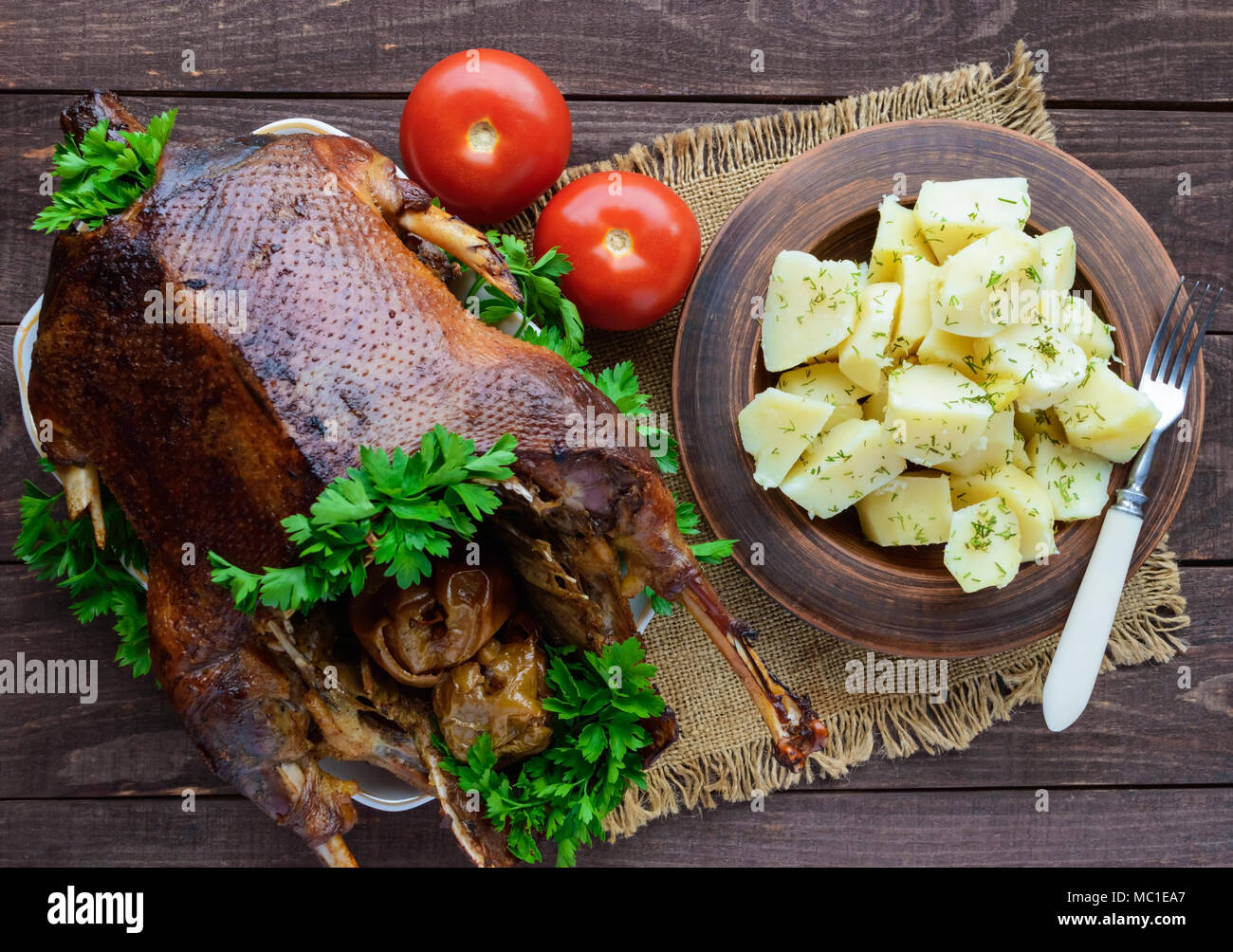 Boiled potatoes in a clay bowl and roasted goose. The top view Stock ...