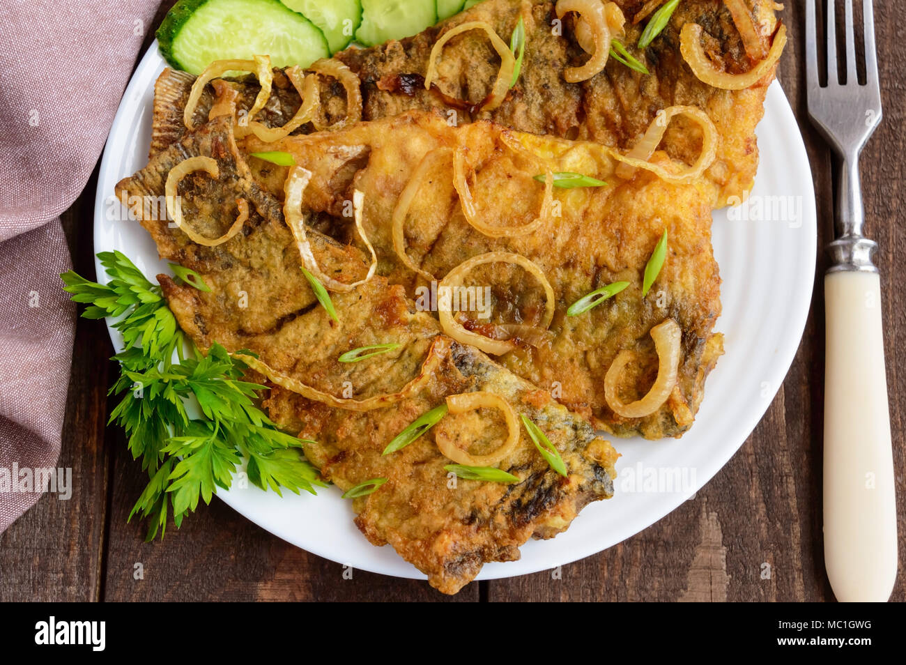 Fried carp fish fillet in batter on wooden table. The top view. Close ...