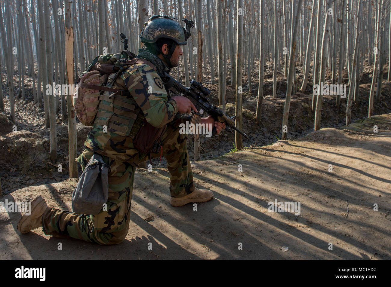 A 10th Special Operations Kandak Commando protects the movement of the ...