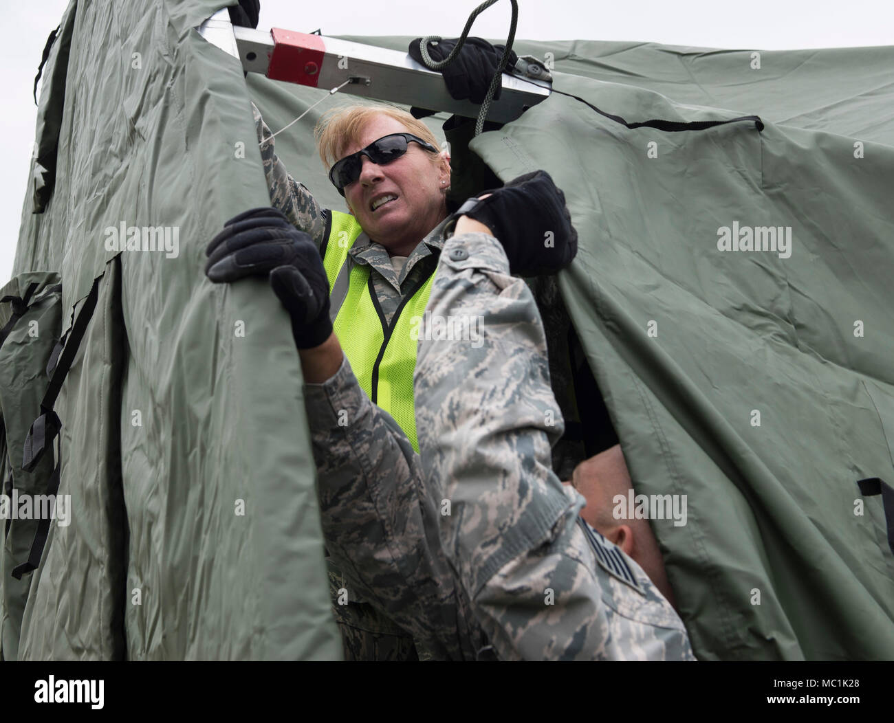 Members of the 18th Medical Group assemble a tent near the flightline ...