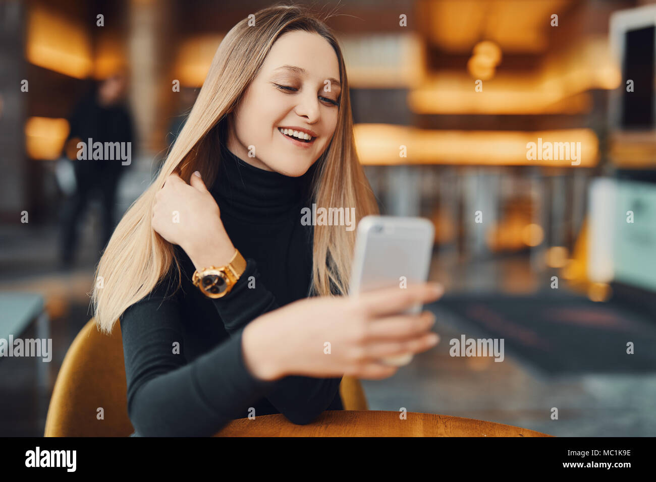 Girl sit at chair and look at her phone Stock Photo - Alamy