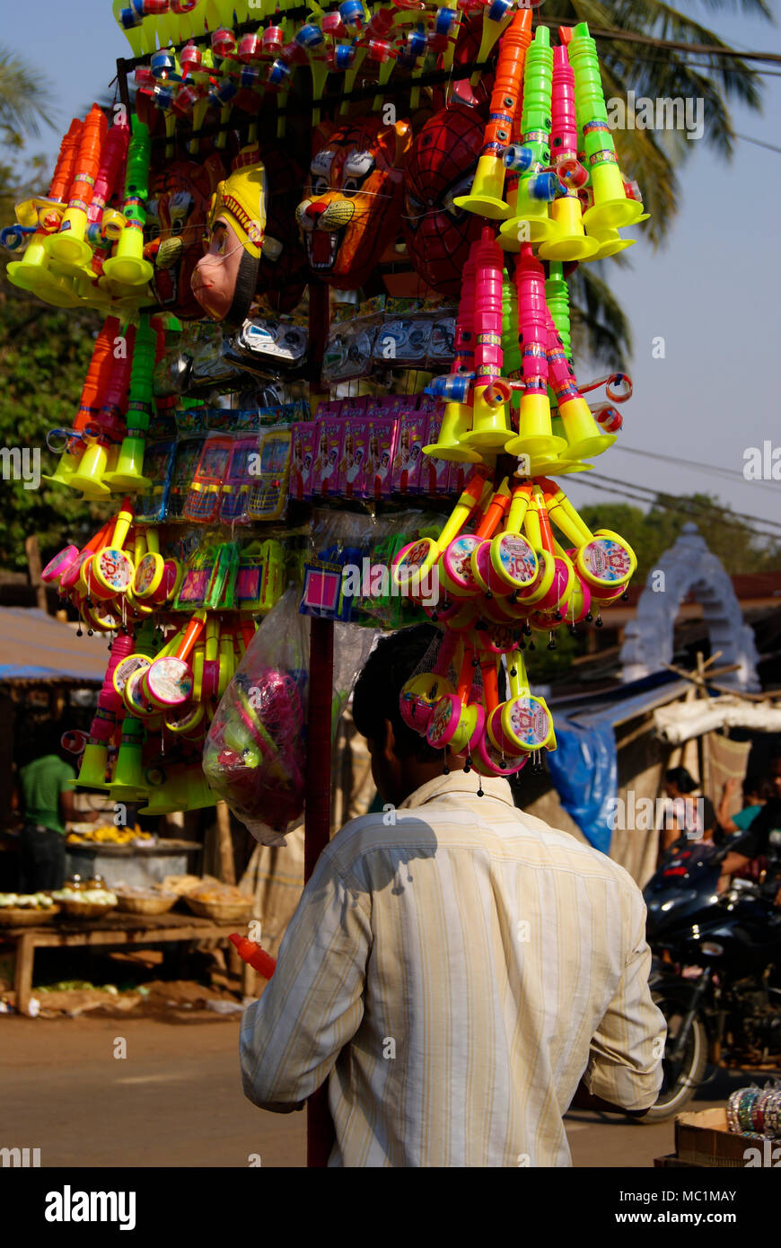 A man selling cheap and colorful toys in the street in Kerala India ...