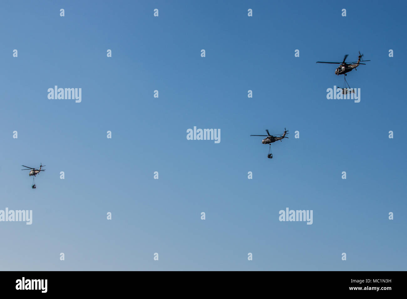 UH-60 Black Hawk helicopters sling load M119A3 Howitzers to a firing ...