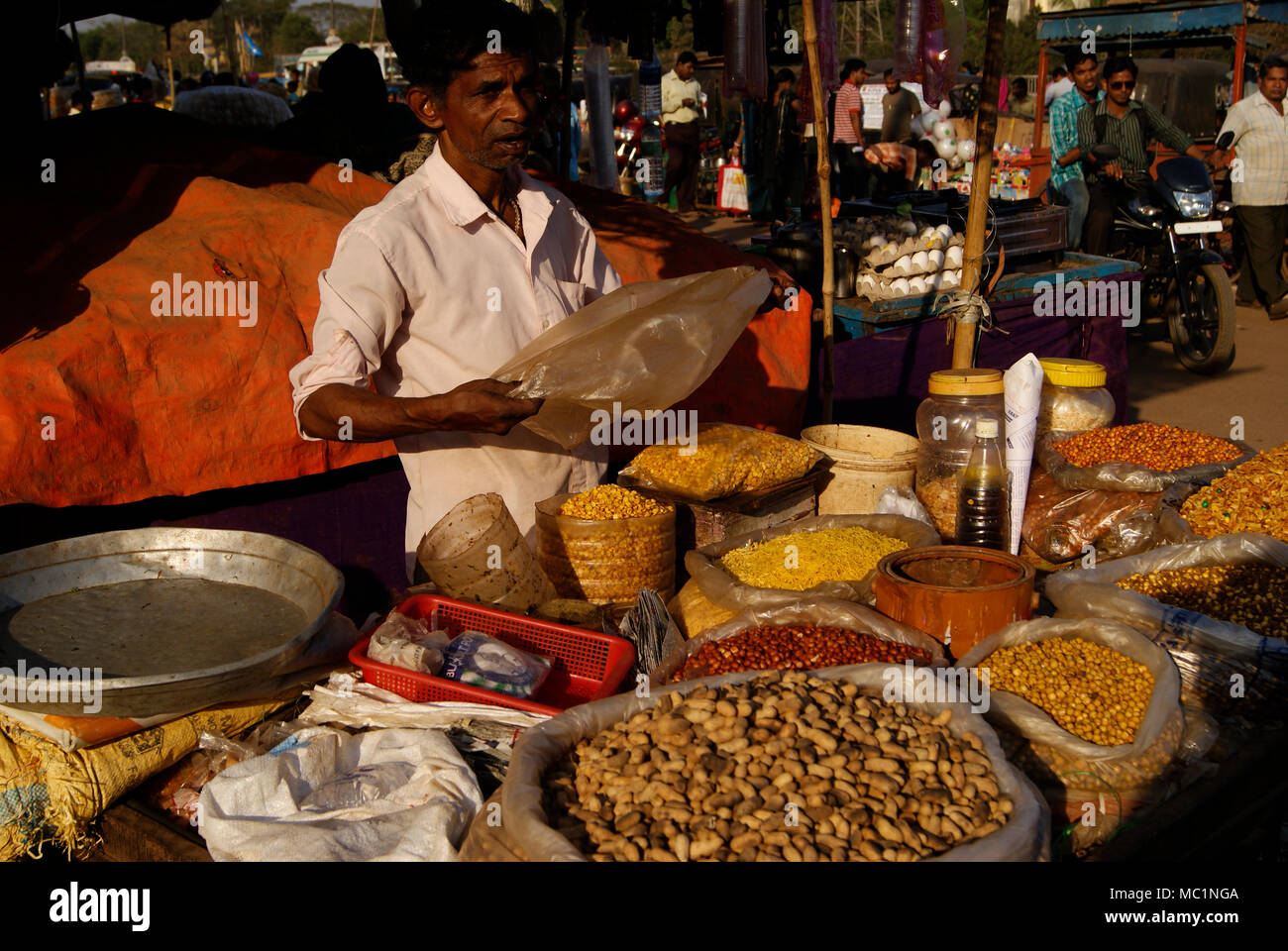 Street food stall in open market salesman selling variety of spicy nuts ...