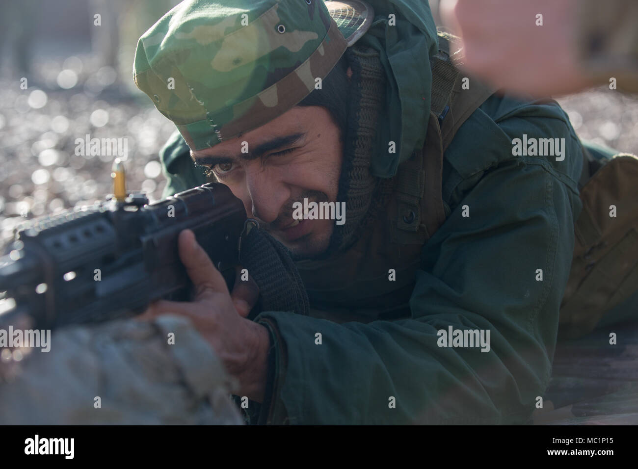 A Coalition partner and security force member balances a bullet, on the ...