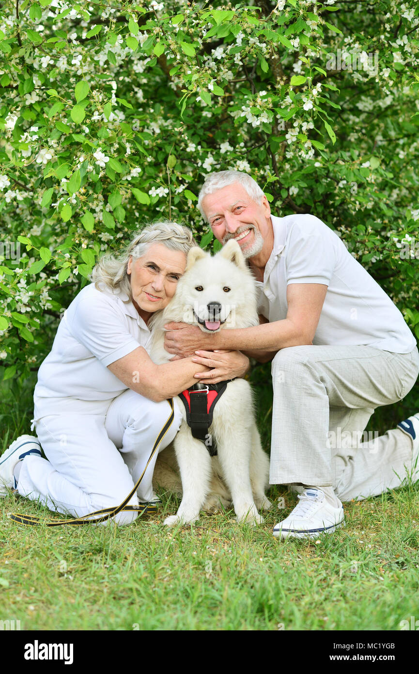 Happy couple hugging dog Stock Photo - Alamy