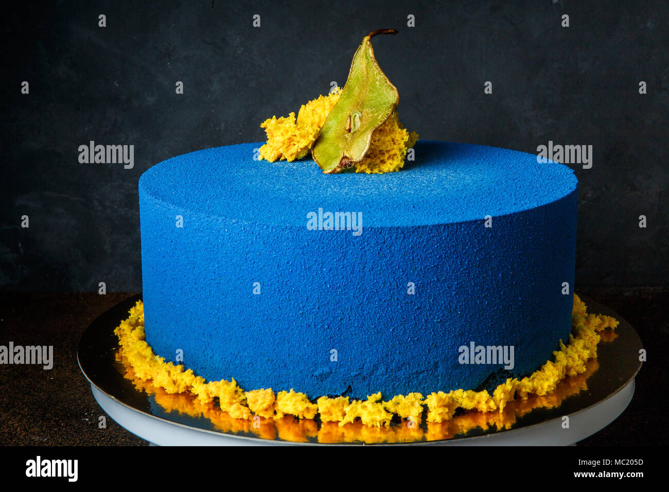 homemade blue round cake decorated with dried pear and pieces of yellow ...