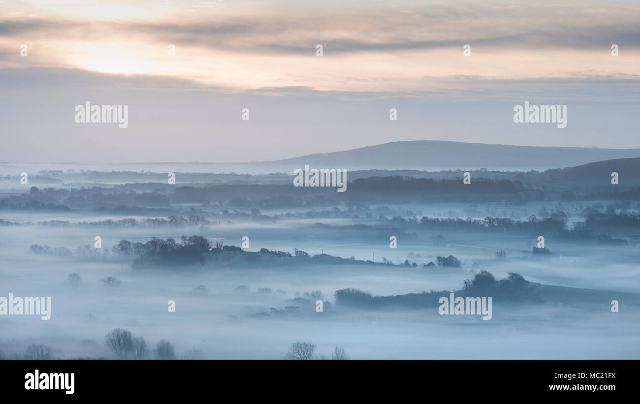 Beautiful foggy English countryside landscape at sunrise in Winter with ...
