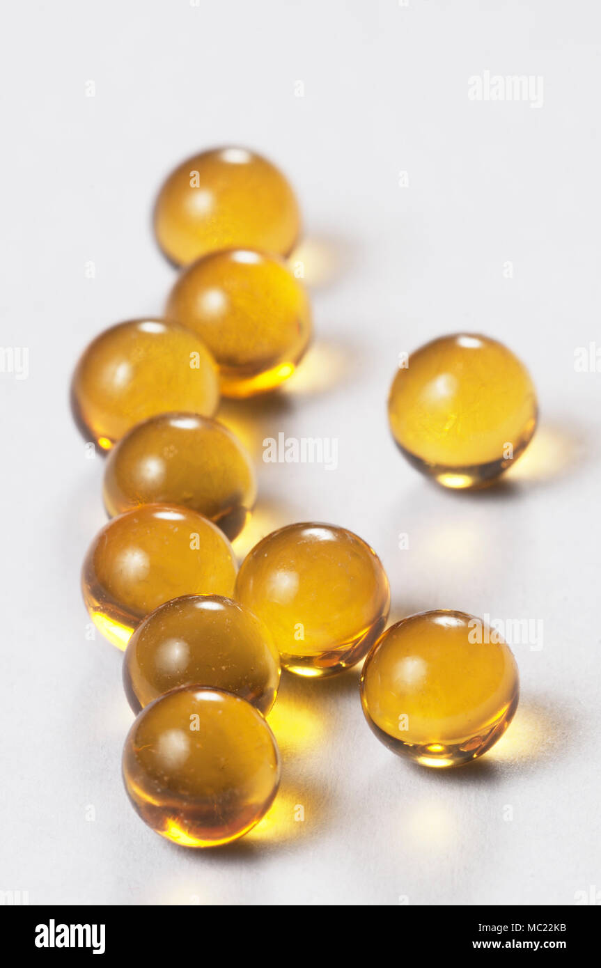Yellow capsules over the light background Stock Photo - Alamy
