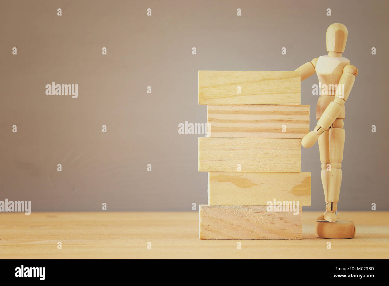 Concept of building success. Wooden dummy standing next to empty blocks ...