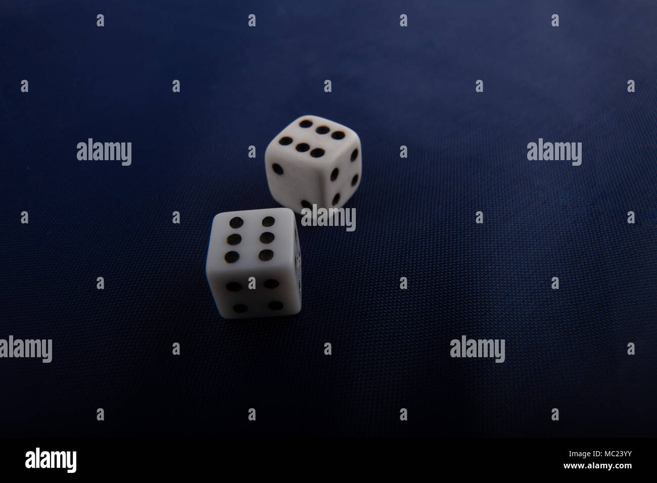 Two white dice cubes showing six on blue background. High angle view ...