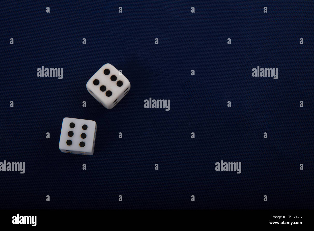 Two white dice cubes showing six on blue background. Top view with copy ...