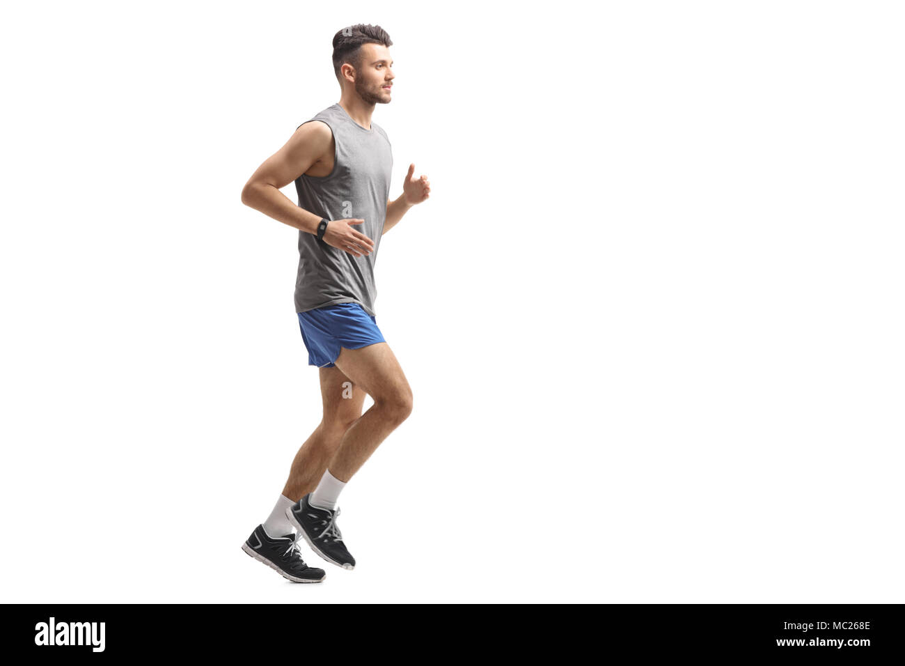 Full length profile shot of a young man in sportswear running isolated ...