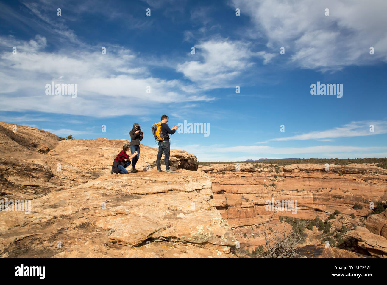 A family of three hikers holding cameras photograph the amazing scenery ...