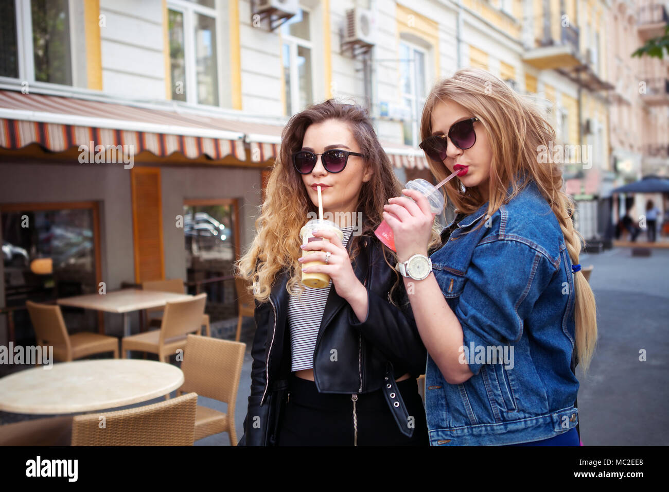 Outdoor lifestyle portrait of two happy best friend girls walk laugh ...